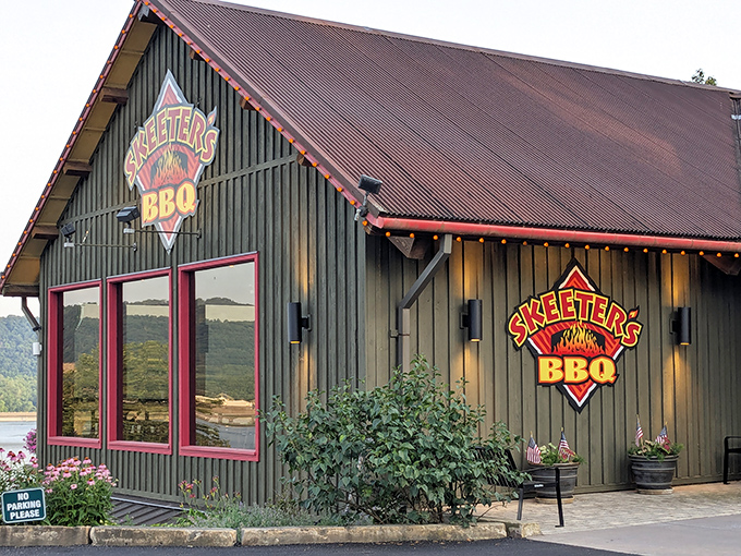 The green cabin-like exterior of Skeeter's BBQ stands like a rustic temple to smoked meat, its red-trimmed windows promising delicious secrets within.