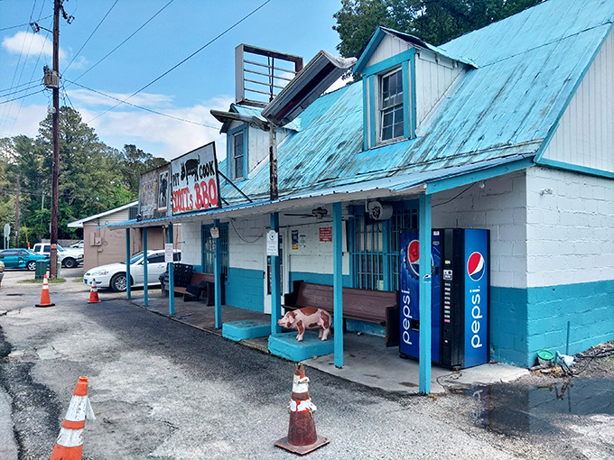 The weathered metal roof and humble blue trim might not scream "culinary destination," but that "PIT COOK" sign tells the real story. BBQ pilgrimage begins here.