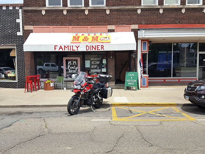 The unassuming storefront of M & M Family Diner beckons hungry travelers with its classic white awning and red lettering—proof that culinary treasures often hide in plain sight.