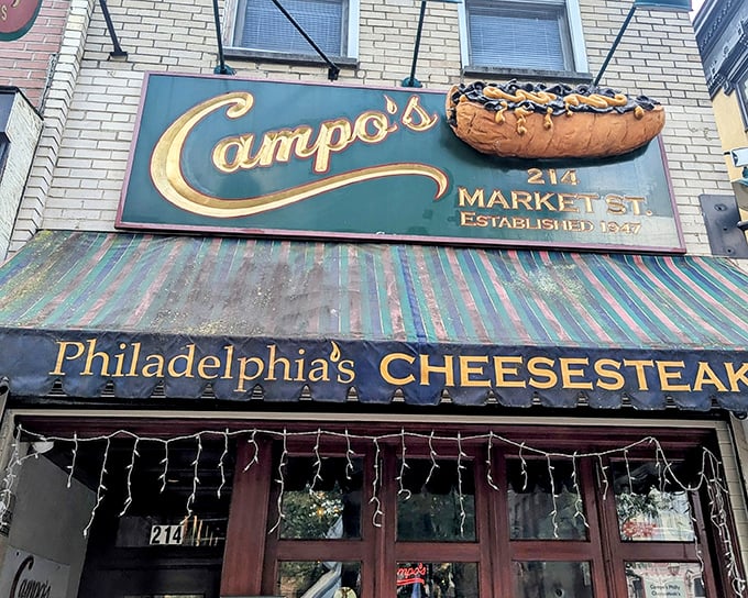 Campo's iconic storefront beckons with its giant cheesesteak sign – like a meaty lighthouse guiding hungry souls through Philadelphia's historic streets.
