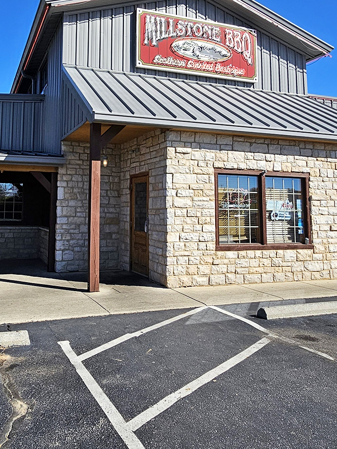 The stone-and-metal exterior of Millstone BBQ stands like a temple to smoked meat devotion, promising delicious treasures within.