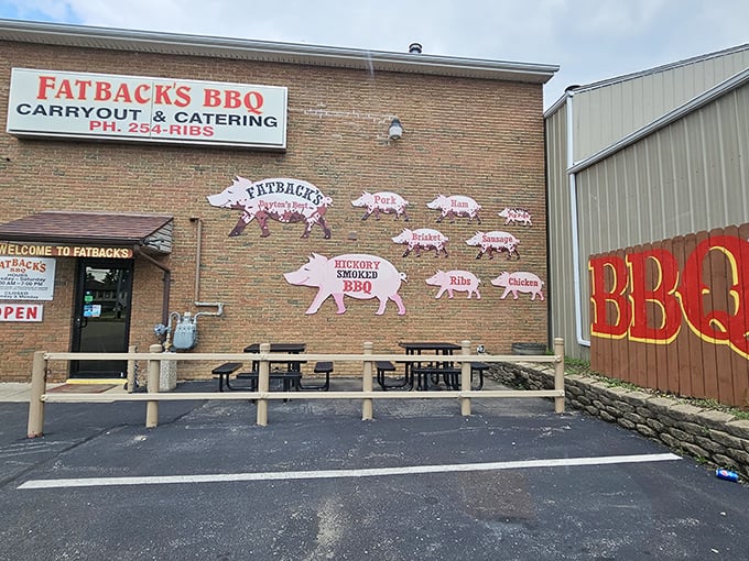 The iconic brick exterior of Fatback's BBQ, where those pig cutouts aren't just decoration—they're a roadmap to smoky paradise.
