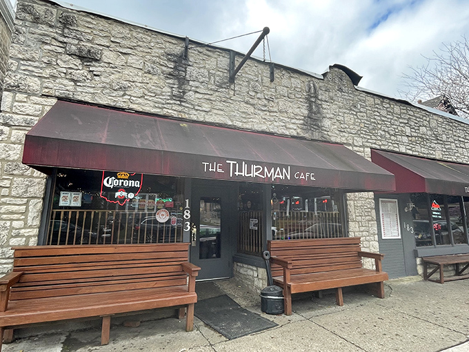 The unassuming stone exterior of Thurman Cafe belies the culinary madness within. Those wooden benches? They're not decorative—they're survival gear for the wait.
