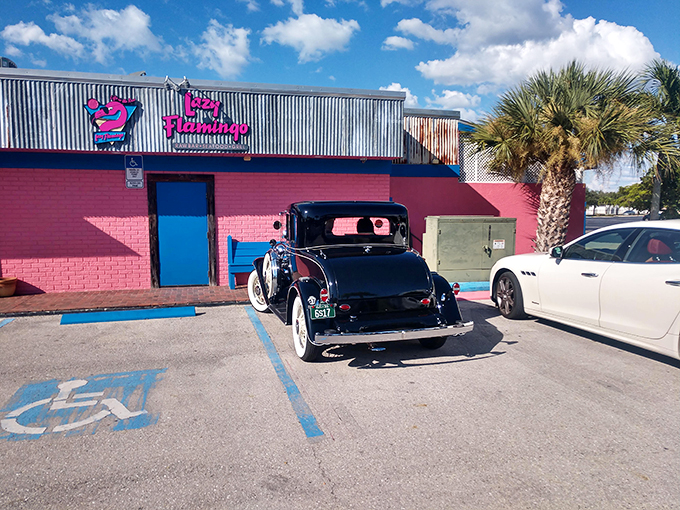 The pink exterior of The Lazy Flamingo isn't just a building—it's a promise of Florida fun that delivers every time. Classic cars and palm trees complete the postcard-perfect scene.