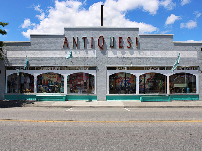 The iconic white facade of Charlotte's Web Antique Mall beckons with its bold "ANTIQUES!" declaration – like a siren song for treasure hunters everywhere.