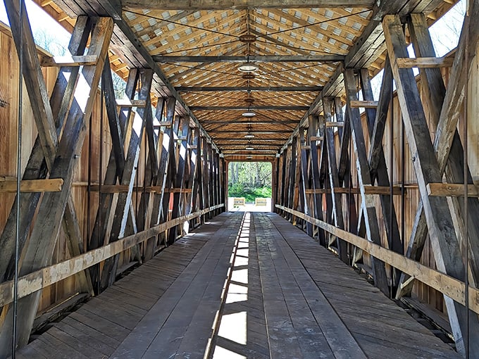 Shadows dance across weathered planks as sunlight streams through the lattice of beams—architectural poetry in wood and light.
