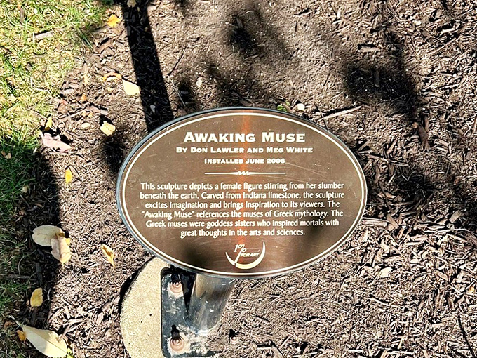 Every great artwork deserves its story told—this plaque reveals the mythology behind the massive emerging figure nearby.