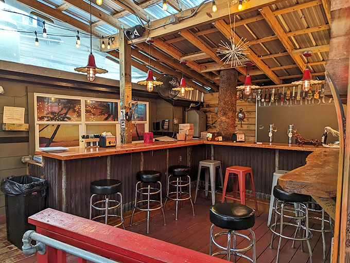 The bar area glows with neon warmth, inviting you to pull up a cherry-red stool and stay awhile.