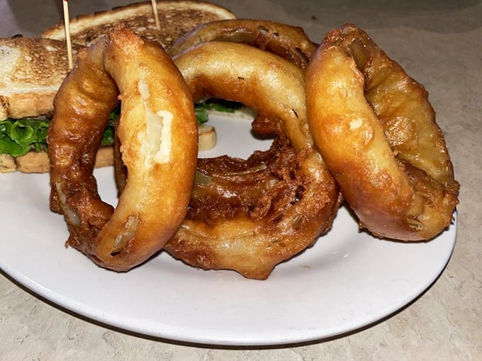Onion rings with the structural integrity of Olympic gold—crispy, golden halos that make fast food versions weep with inadequacy.
