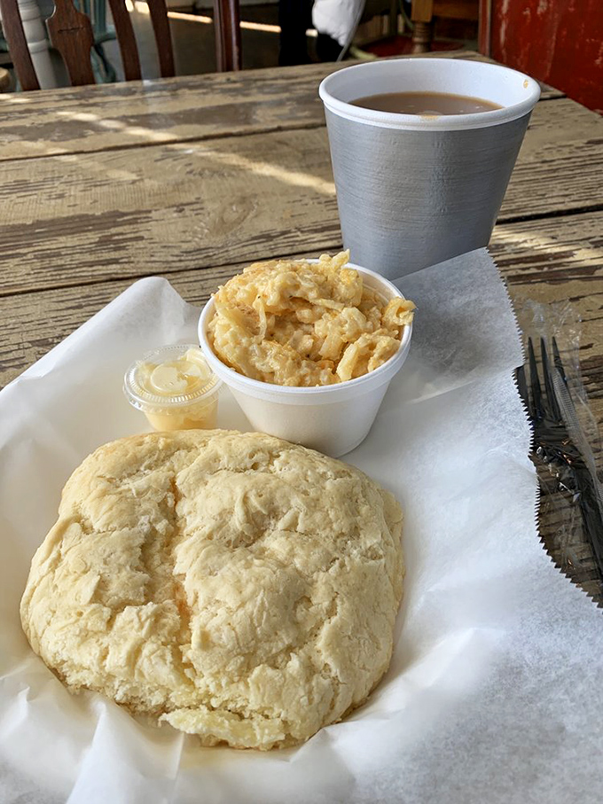 A perfect biscuit, hashbrown casserole, and coffee – the holy trinity of morning salvation on a weathered wooden table.