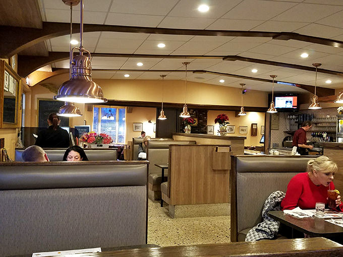 Modern booths and pendant lighting create cozy conversation corners where coffee refills and life stories flow with equal abundance.