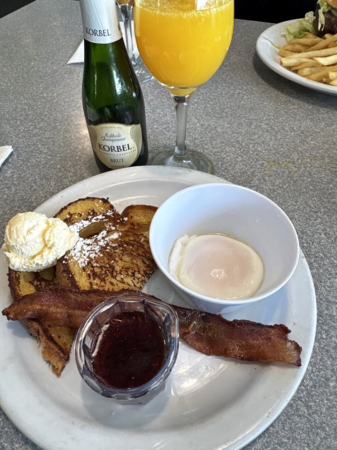 The breakfast trinity: perfect French toast, crispy bacon, and a mimosa. Name a more iconic morning trio—I'll wait.