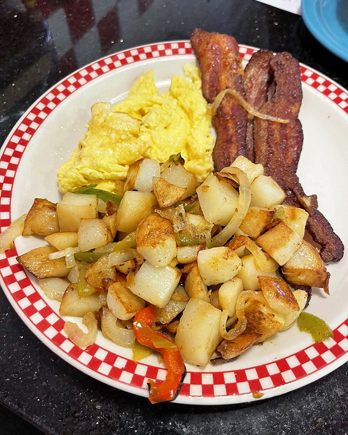 The breakfast trinity: perfectly scrambled eggs, crispy bacon, and home fries with enough character to star in their own sitcom.