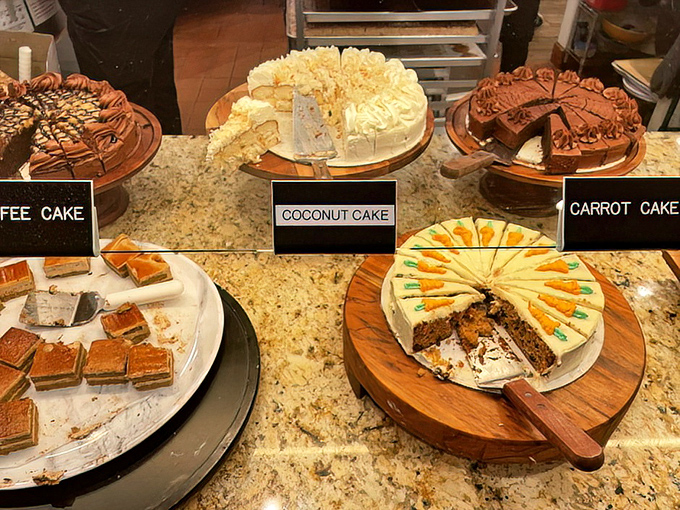 The cake section is where diets go to die happy – coconut, carrot, and coffee cakes standing proud like contestants in a delicious beauty pageant.