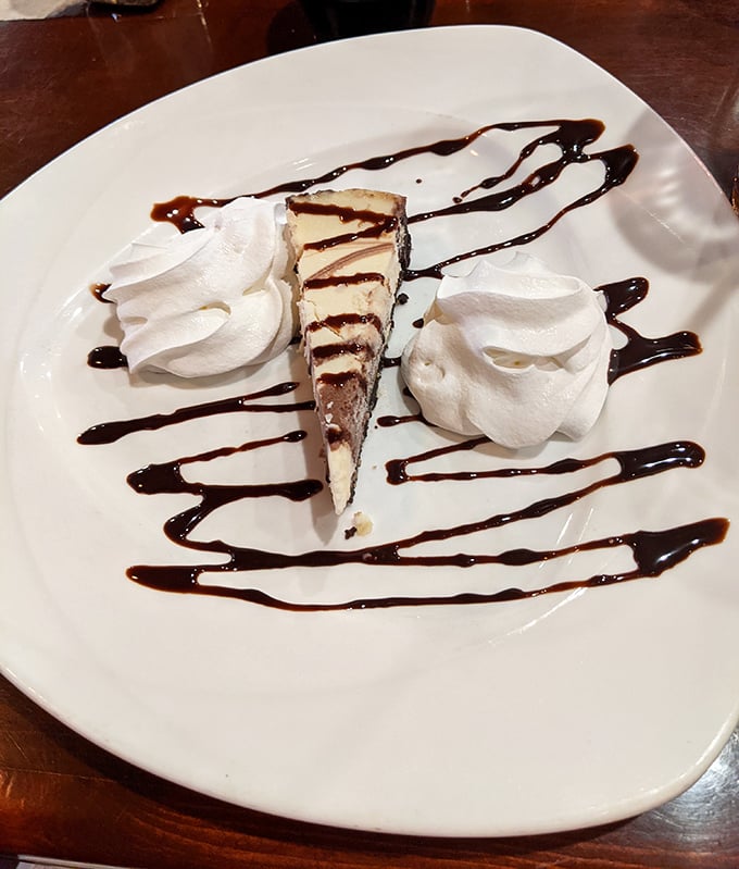 Cheesecake artfully drizzled with chocolate and flanked by whipped cream—because saving room for dessert isn't just suggested, it's practically mandatory.