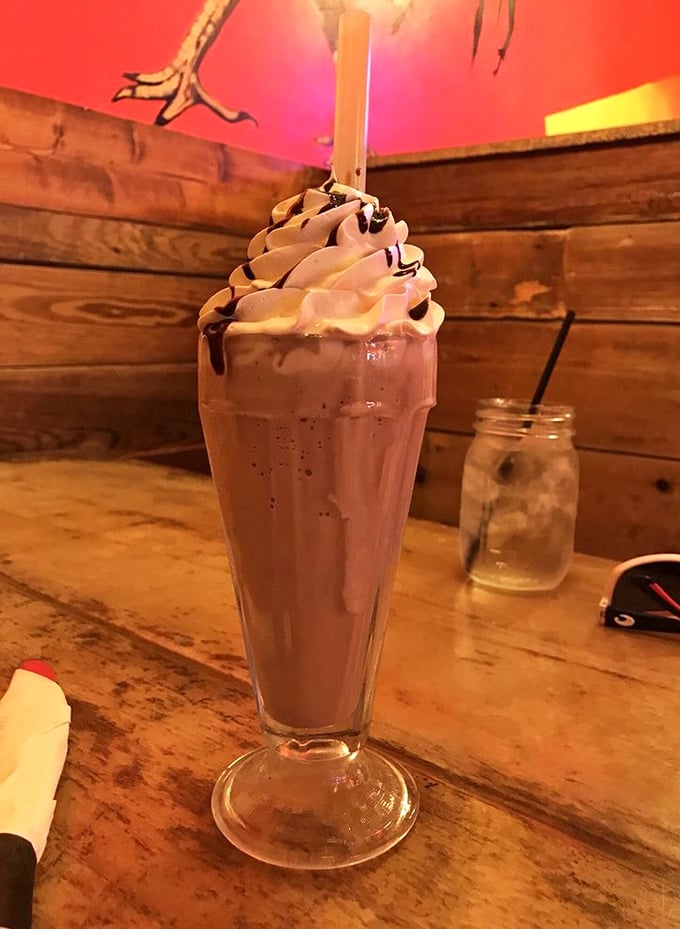 This chocolate milkshake isn't just a drink—it's dessert architecture. The whipped cream tower defies both gravity and willpower.
