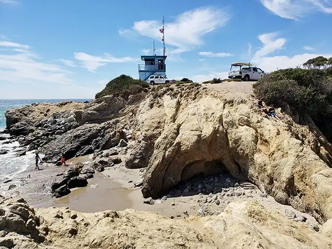 The lifeguard station stands sentinel over this coastal treasure, perched on cliffs that seem straight out of a Mediterranean postcard.
