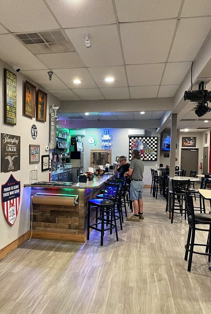 The bar area glows with neon signs and promises of cold beer. After all, what pairs better with barbecue than a frosty brew?