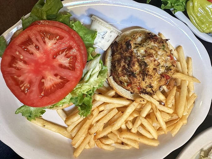 A sandwich that celebrates the sea – golden crabcake, fresh tomato slice, crisp lettuce, and fries that could steal the show if the crabcake wasn't so magnificent.