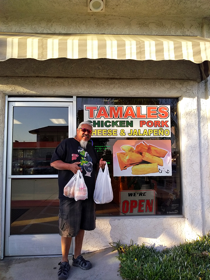 The universal language of tamale joy written on a satisfied customer's face. Two bags suggest either great appetite or excellent planning.