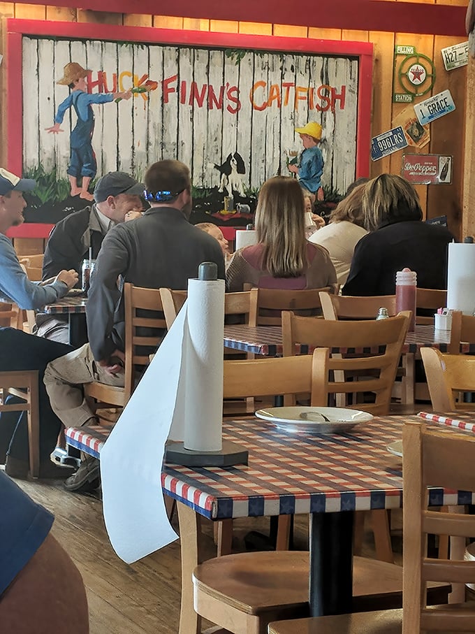 Diners enjoying their meals beneath a charming mural that captures the restaurant's namesake. No phones in sight—just people connected by good food and conversation.