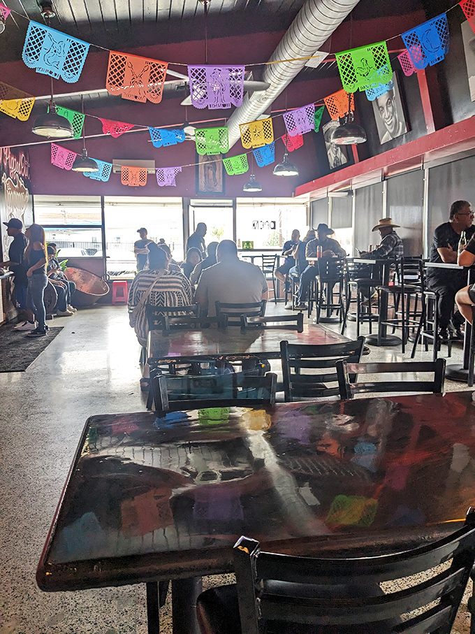 Weekend crowds gather under colorful banners, united in pursuit of pork perfection. The line forms for good reason at this carnitas institution.