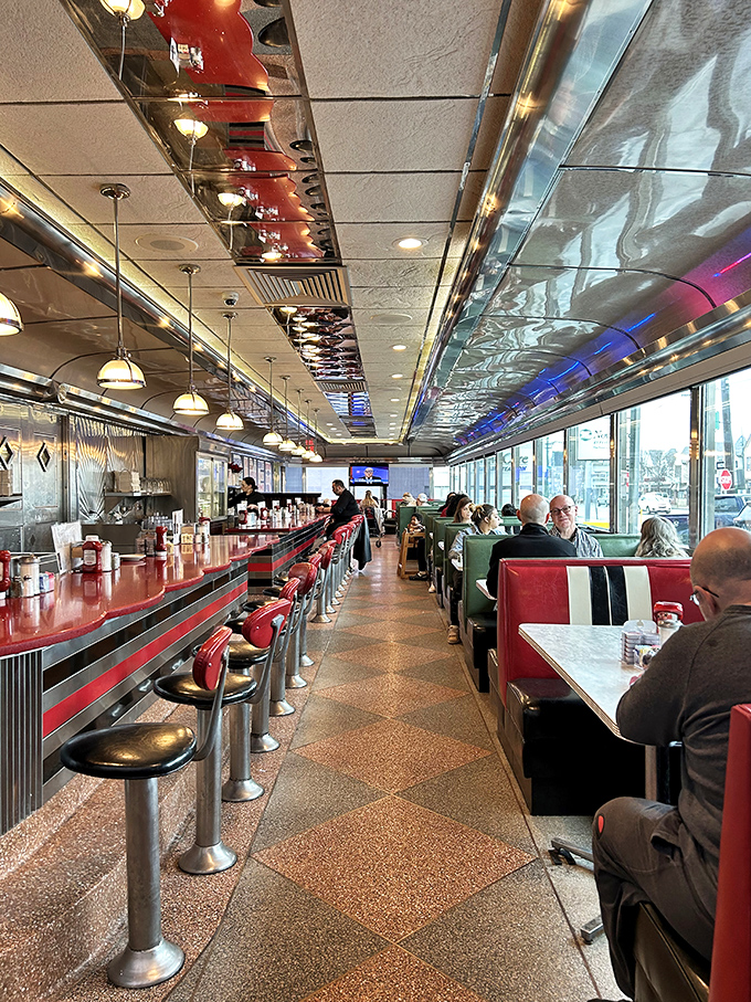 The diner's layout perfected: a runway of red and chrome where breakfast dreams come true while Philadelphia hustles outside.