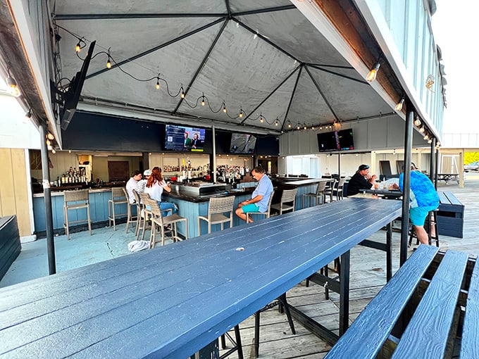 The covered outdoor bar area invites lingering over cold drinks and hot gossip. Maryland sports memorabilia reminds you exactly where these crabs call home.