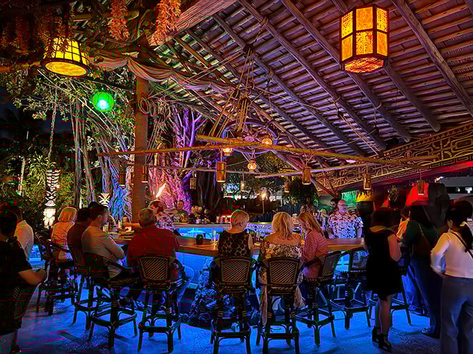 The outdoor bar area comes alive at night, where strangers become friends under thatched roofs and the glow of colorful lanterns.