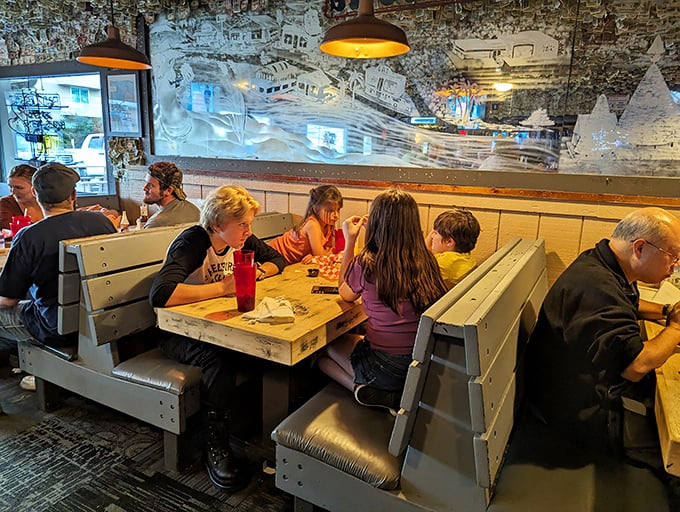 Families gather in wooden booths beneath the famous dollar-bill decor, creating new memories while surrounded by evidence of countless good times past.