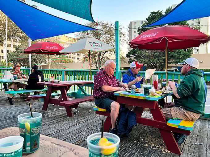 The outdoor deck where vacation time slows down. Three guys, three burgers, and absolutely zero hurry to be anywhere else.