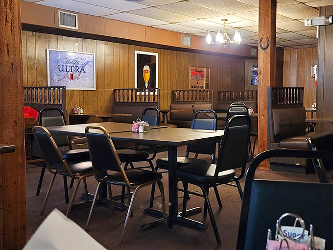 No-nonsense seating in a room where beer signs serve as art—because when the steaks are this good, who needs fancy chandeliers?