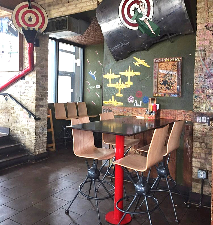 Aviation-themed touches adorn the walls while model planes stand ready to deploy—this isn't just décor, it's dinner theater for your burger experience.
