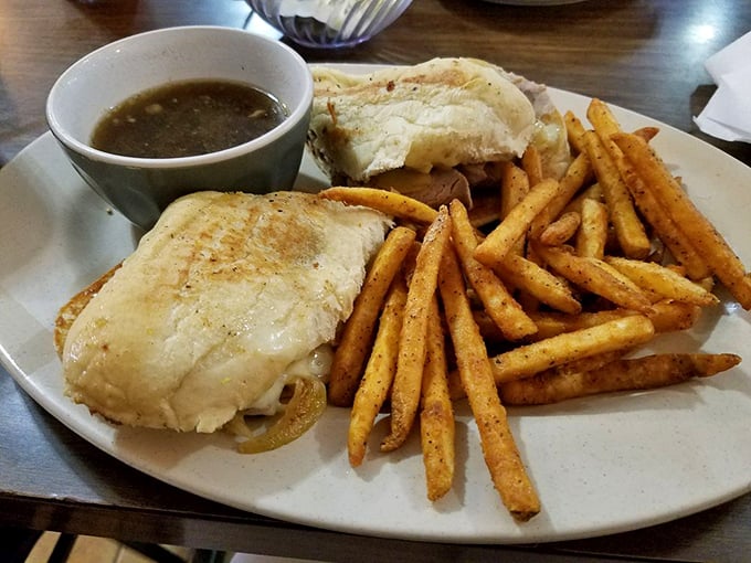 A French dip sandwich with fries that proves dipping isn't just for swimming pools—it's the highest form of sandwich appreciation.