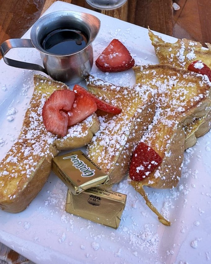 French toast that doesn't just break the fast—it demolishes it with golden custard-soaked bread and berries wearing powdered sugar like fresh snow.