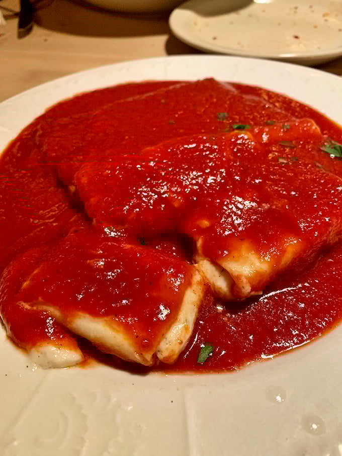 Fresh manicotti swimming in marinara—like little pasta canoes navigating a delicious red sea toward your eager fork.