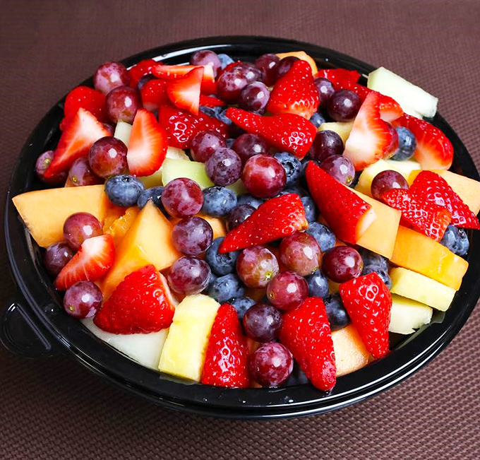 A vibrant fruit salad offers a refreshing counterpoint to the savory menu stars—proof that balance exists even in cheesesteak paradise.