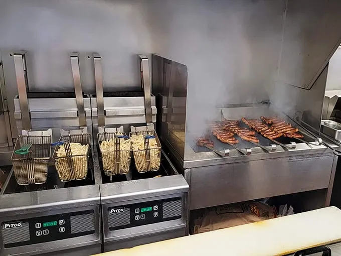 Where the magic happens—sausages sizzling on the grill while fries bubble in oil, a beautiful choreography of comfort food creation.