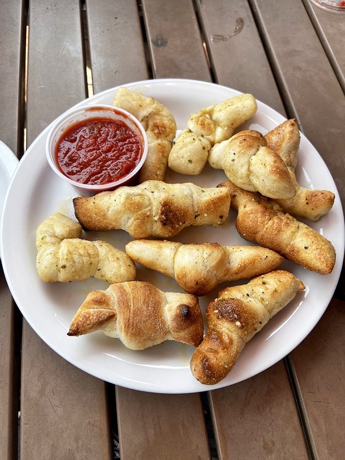 Garlic knots twisted with such care they look like they're doing yoga poses before their marinara sauce bath.