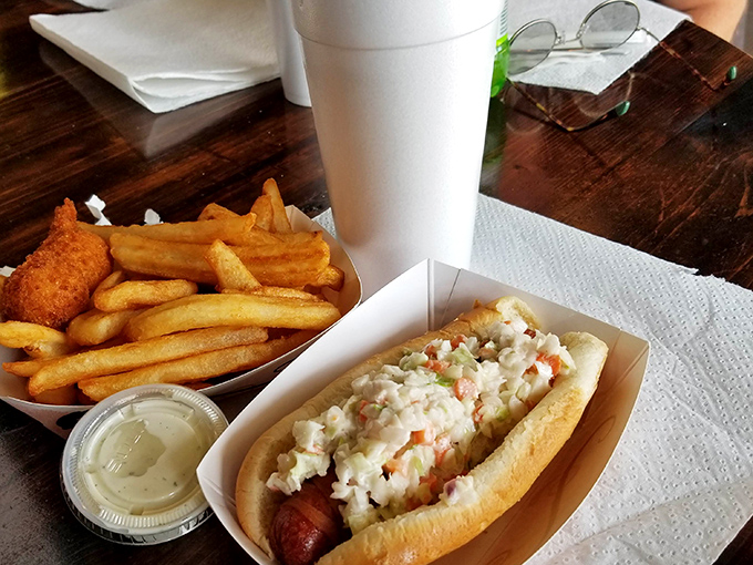 The hot dog comes dressed for success with a creamy slaw topping—proving that even the simplest pleasures deserve a touch of culinary respect.