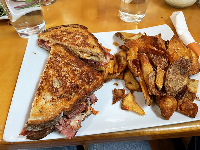 This sandwich isn't just lunch—it's architecture. Layers of savory goodness stacked between perfectly griddled bread with fries playing a supporting role.