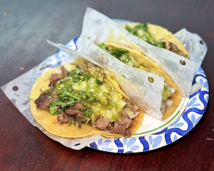 Lengua tacos topped with vibrant salsa verde – adventurous eating has never looked so inviting.