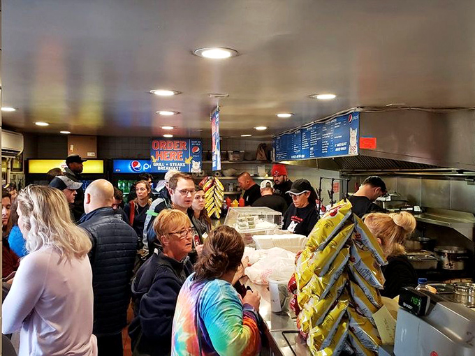 The line forms with purpose—strangers united by a common mission to experience what might be the best sandwich day of their lives.