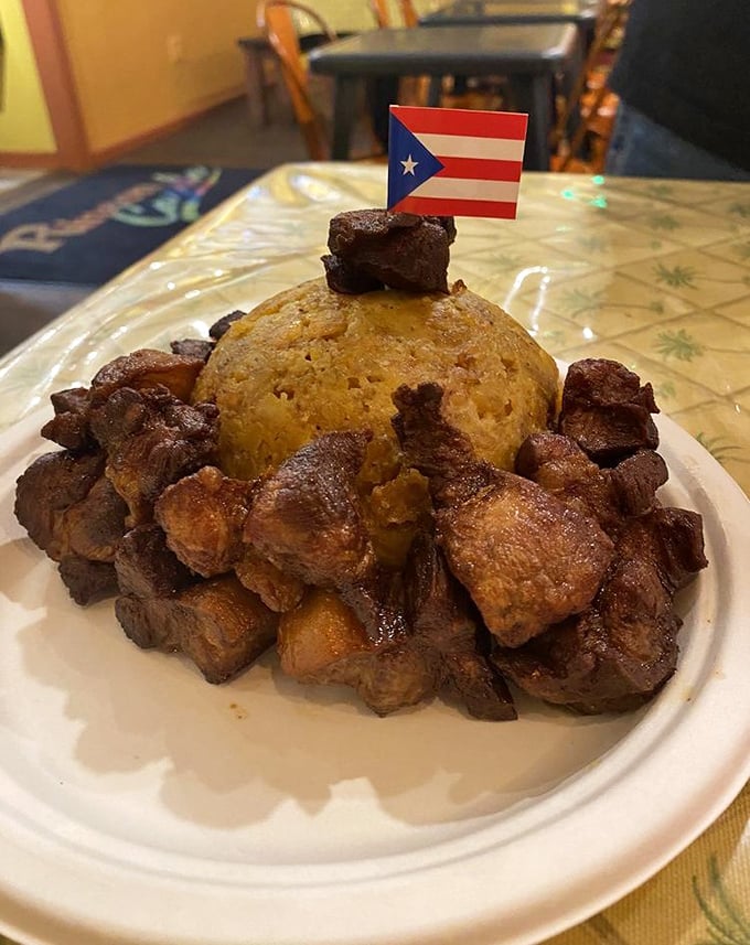 Mofongo crowned with a Puerto Rican flag—this mountain of mashed plantains and savory pork is a patriotic plate of pure comfort.