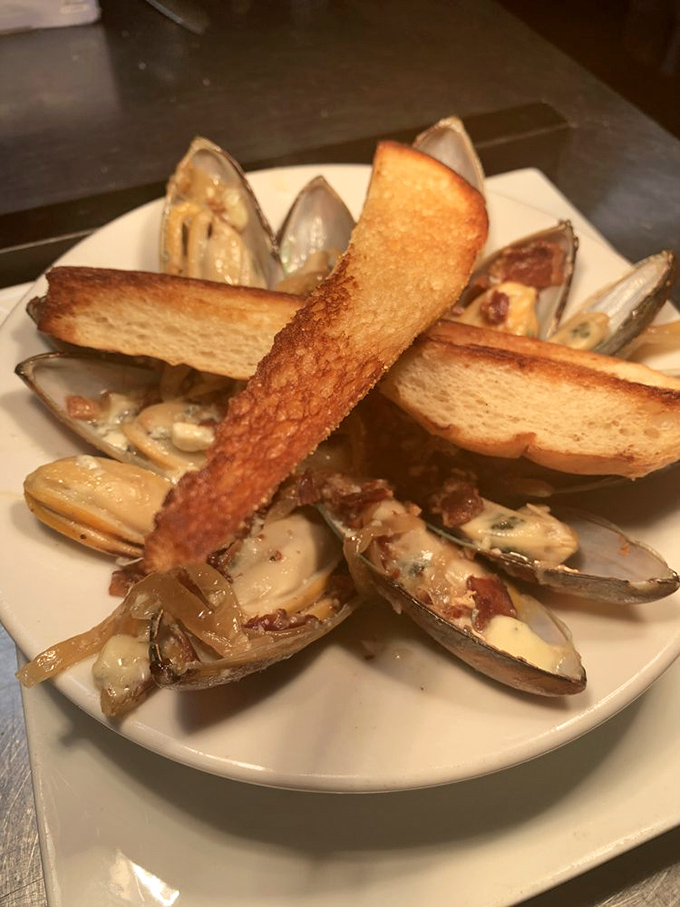 These mussels aren't just served—they're presented like the seafood royalty they are. The toasted bread stands ready to soak up that ambrosial broth.