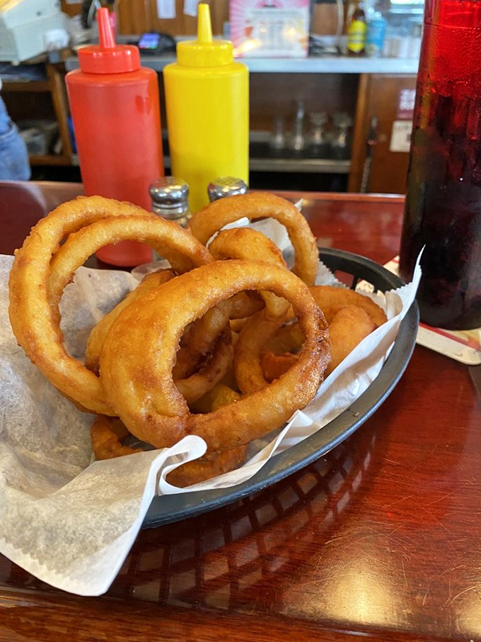 Onion rings that could double as golden bracelets. Crispy, not greasy, with sweet onion inside that pulls away cleanly with each bite.