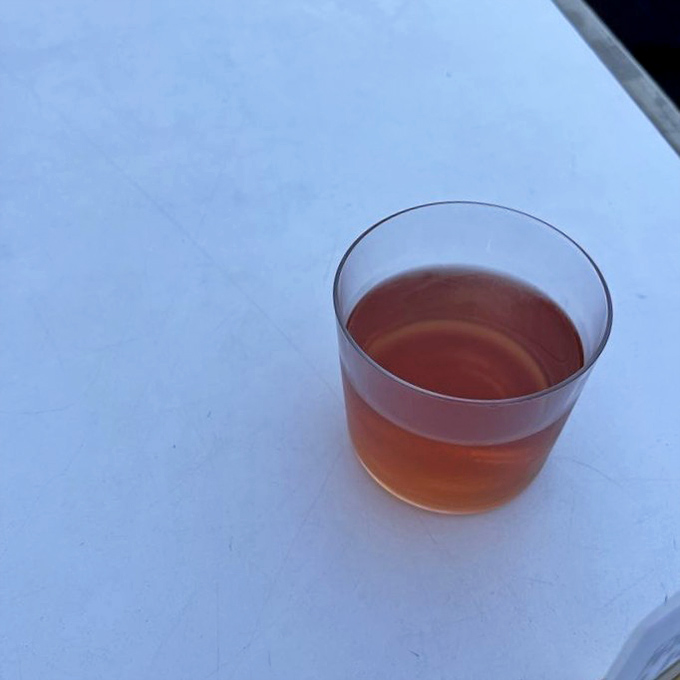 Orange wine catching the light like liquid amber—proof that sometimes the best things in life aren't red, white, or rosé.