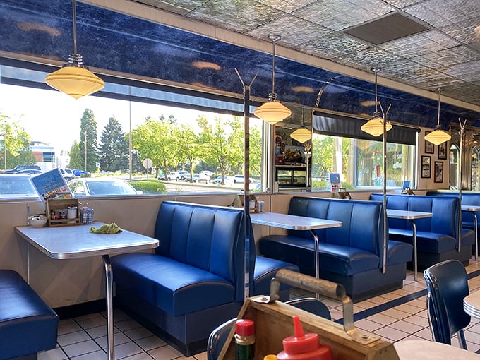 Blue booths bathed in natural light create the perfect backdrop for comfort food conversations. Every table has a story.