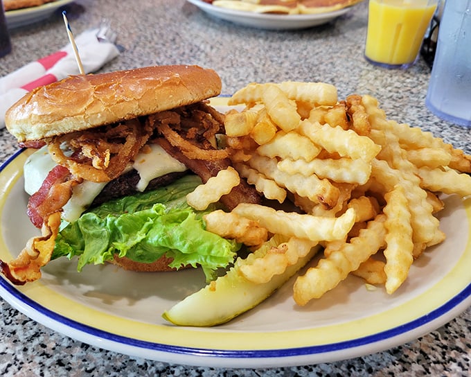 This isn't just a burger—it's an architectural masterpiece of beef, cheese, and toppings, with crispy fries standing guard like delicious sentinels.