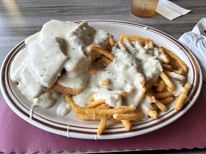 Gravy isn't just a topping here; it's practically a philosophical statement. This open-faced sandwich with fries doesn't just feed you—it hugs you from the inside out.